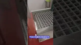 The flight‑type commercial dishwasher is undergoing on‑site installation and commissioning.