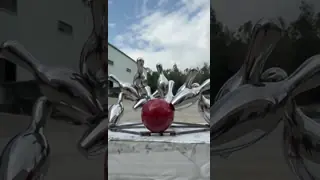The mirrored stainless steel bowling sculpture vividly captures the dynamic moment