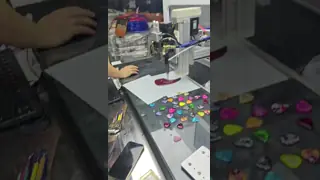 This automatic sticker dispensing machine combines sticker attachment and glue dispensing processes.
